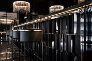 Um interior moderno com superfícies refletoras e iluminação ambiente.