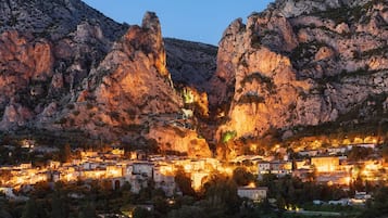 Uma cidade aninhada em um vale, com edifícios iluminados ao fundo de montanhas.