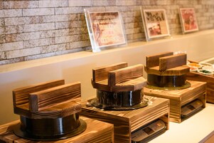 Exposição de recipientes de madeira para alimentos, com uma balança e quadros de menu ao fundo.