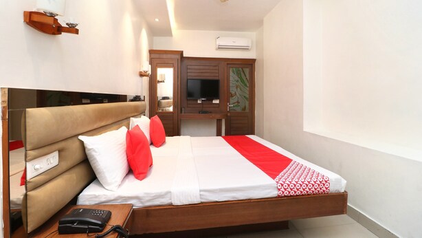 Quarto com cama, mesa de cabeceira e ventoinha no teto.