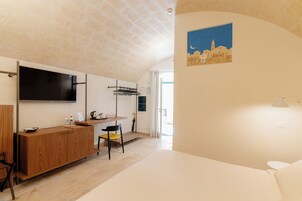 Quarto moderno com escrivaninha de madeira, uma cadeira, televisão de tela plana na parede e uma pintura de uma paisagem urbana.