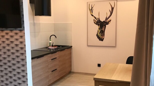 Cozinha moderna com fogão embutido, pia e ar-condicionado fixado na parede.