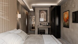 Quarto de hotel moderno com uma cama grande, um pequeno espaço de estar, lareira e obras de arte nas paredes.