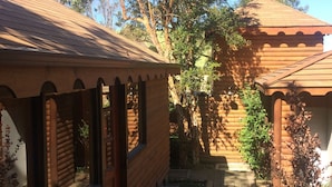Uma cabana de madeira com varanda coberta e um deck de madeira.