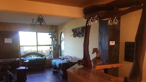Um quarto aconchegante com uma cama, uma escrivaninha de madeira e uma janela grande.
