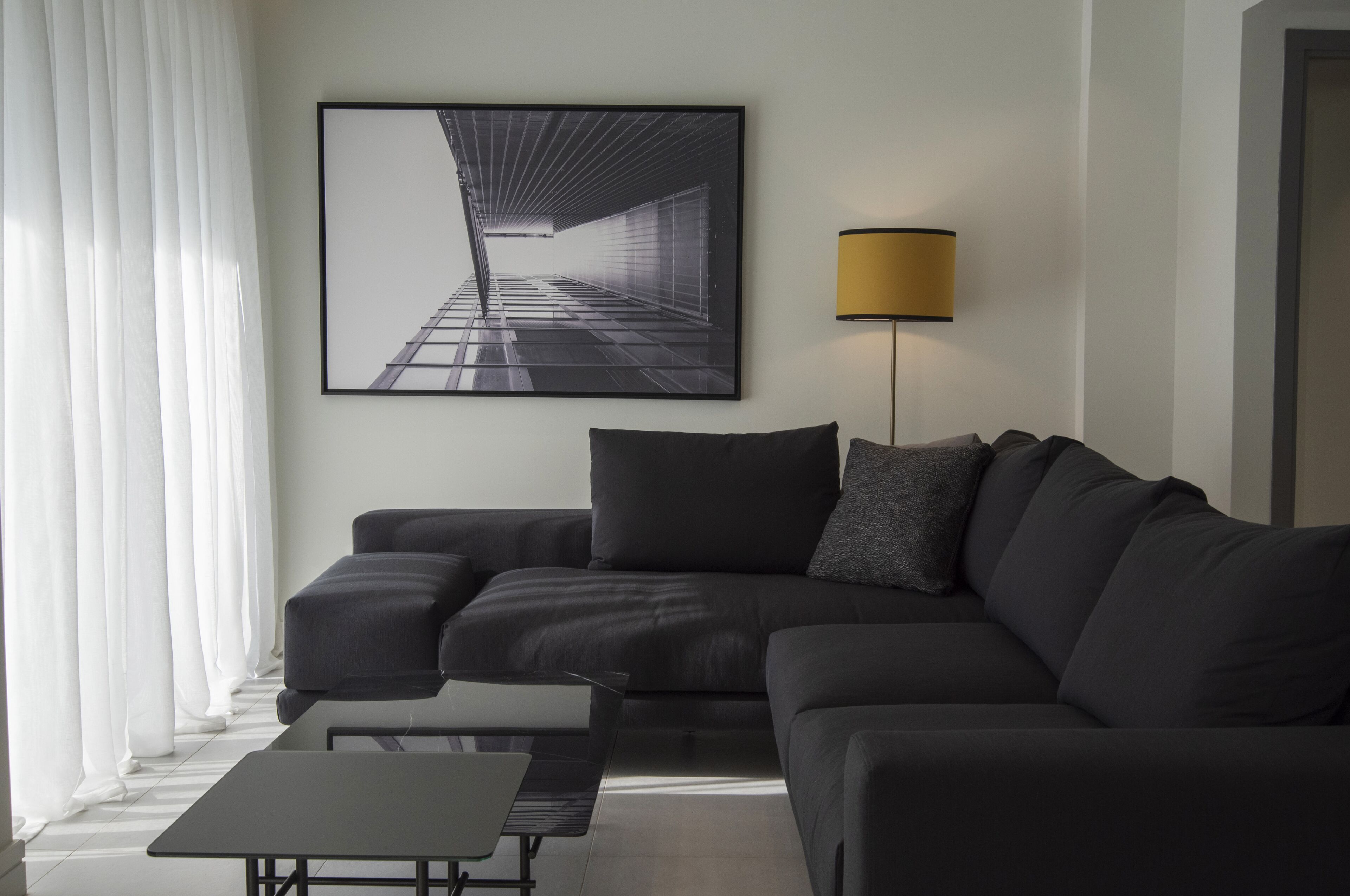 Uma sala de estar moderna com um sofá seccional, uma mesa de centro e um abajur.