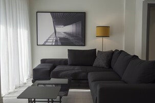 Uma sala de estar moderna com um sofá seccional, uma mesa de centro e um abajur.