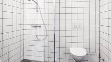 Um banheiro pequeno, revestido com azulejos, com chuveiro, vaso sanitário e interruptor de luz na parede.