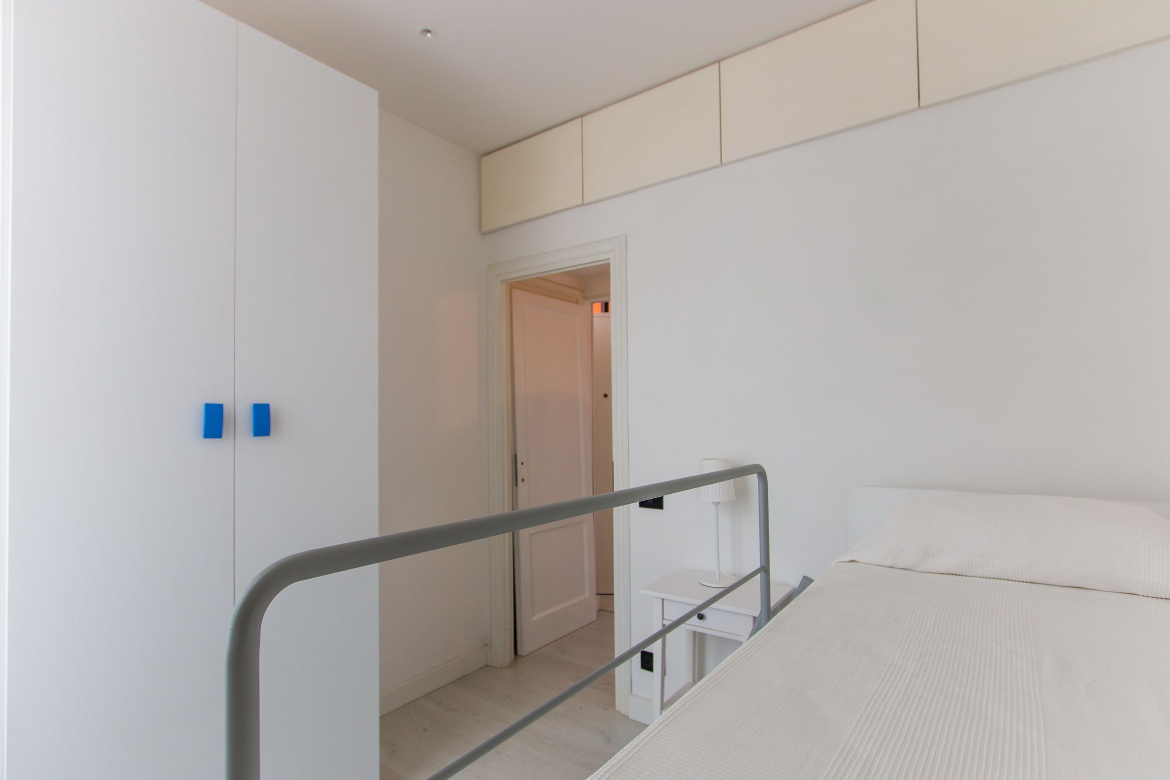 Quarto com uma cama, guarda-roupa e escrivaninha.