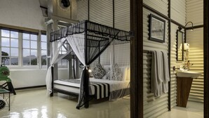 Quarto com cama de dossel, janela com vista, pia e espelho.