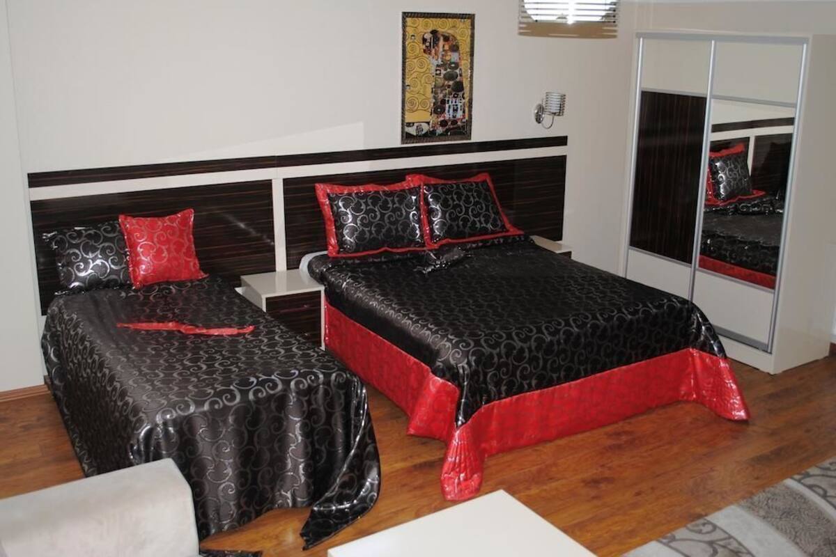 Quarto com duas camas, um espelho e uma mesa de cabeceira.