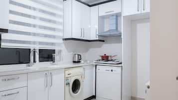 Um frigorífico, uma placa de cozinha, uma cafeteira/bule