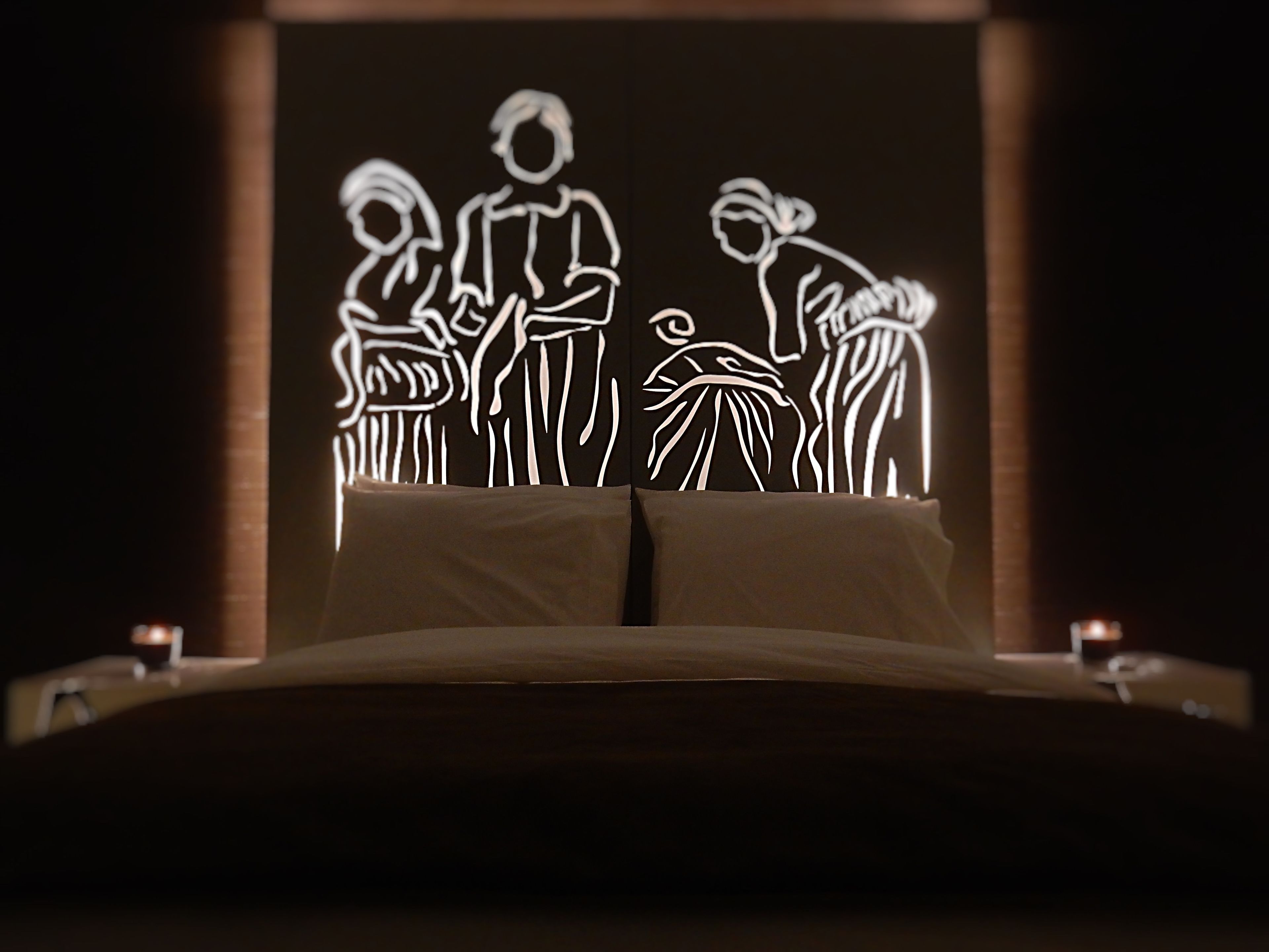 Uma cama com cabeceira que apresenta o desenho de uma família.