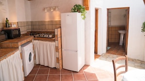 Uma cozinha compacta com máquina de lavar, geladeira e pia.