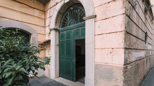 Um edifício com porta verde e placa com o número 11.