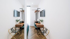 Um interior moderno com uma parede espelhada que reflete uma área de jantar, uma escrivaninha de madeira e uma cadeira.
