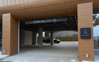 Entrada de estacionamento com placa indicando "PARKING LOT" e restrição de altura de 2,7m.