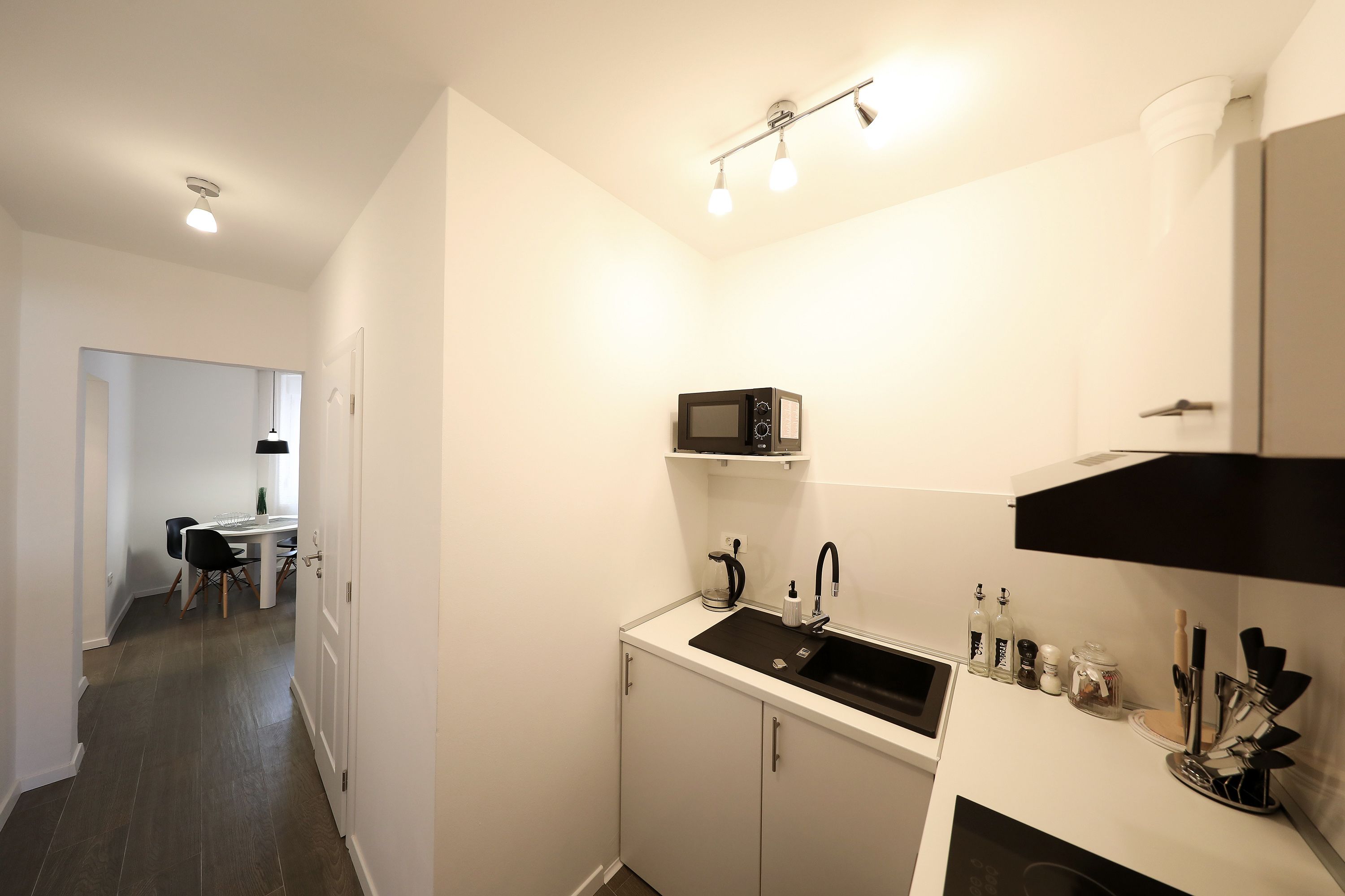 Cozinha compacta com pia, micro-ondas e um pequeno balcão.