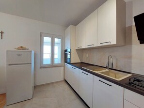 Apartamento (A1) | Cozinha privada | Um frigorífico, um micro-ondas, um forno, uma placa de cozinha 