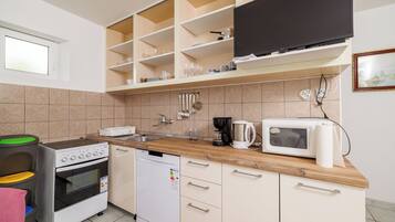 Apartamento (A1) | Cozinha privada | Um frigorífico, um micro-ondas, um forno, uma placa de cozinha