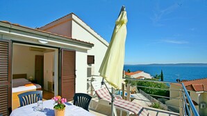 Varanda com mesa, cadeiras e guarda-sol, com vista panorâmica.