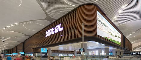 Hotel moderno com placa chamativa, situado num terminal de aeroporto.