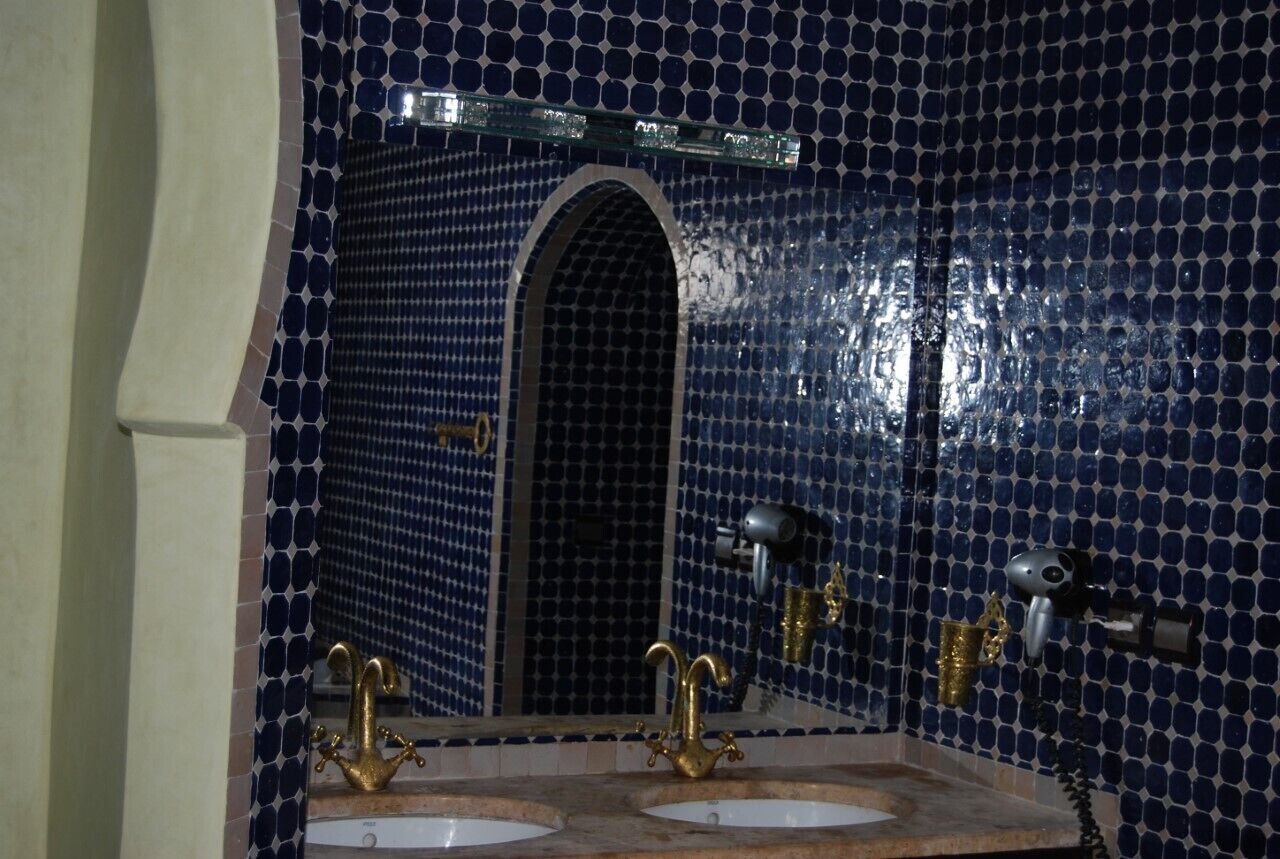 Casa de banho com duas pias, espelho e chuveiro.