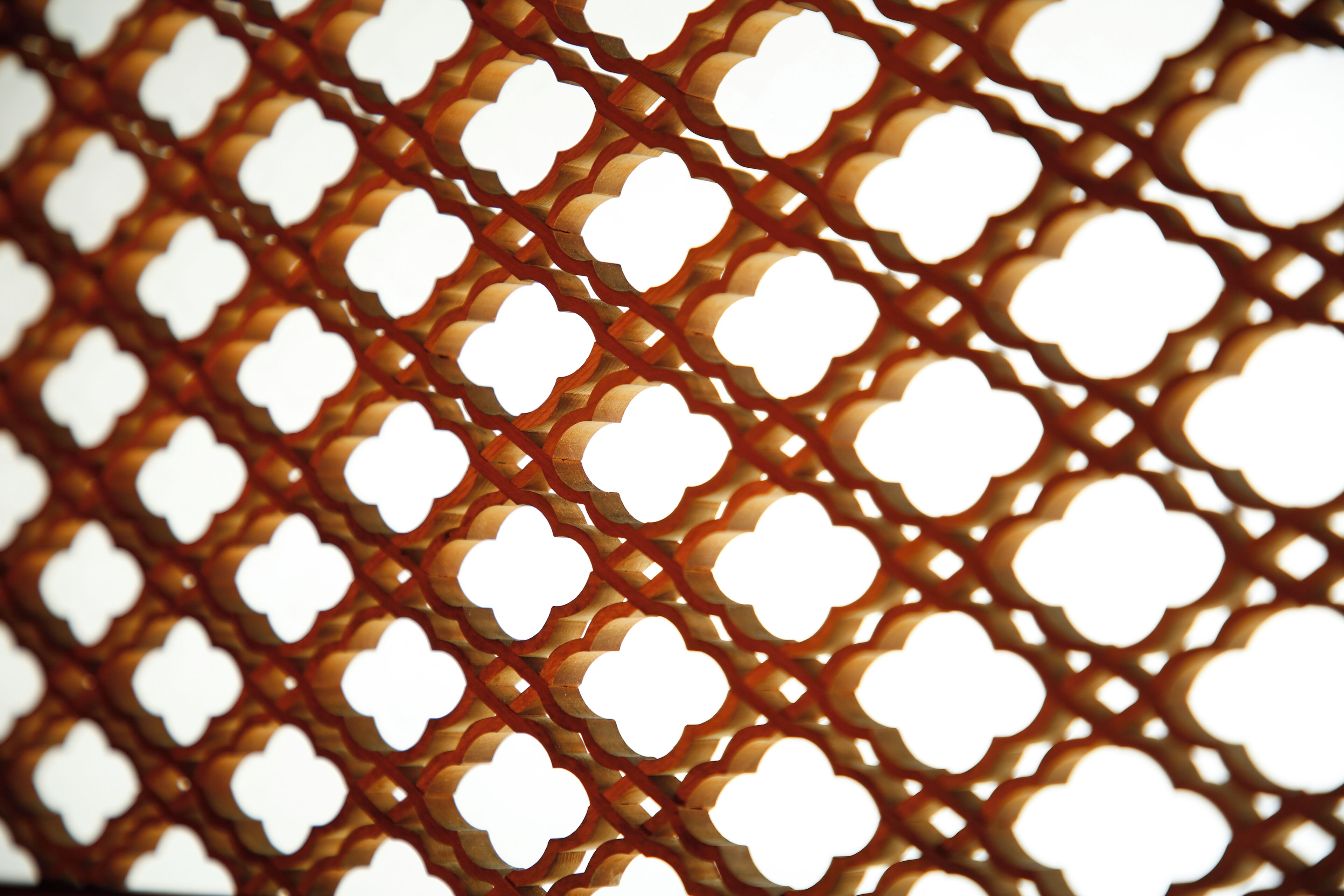 Um close-up de uma malha metálica estampada com um design geométrico repetitivo.