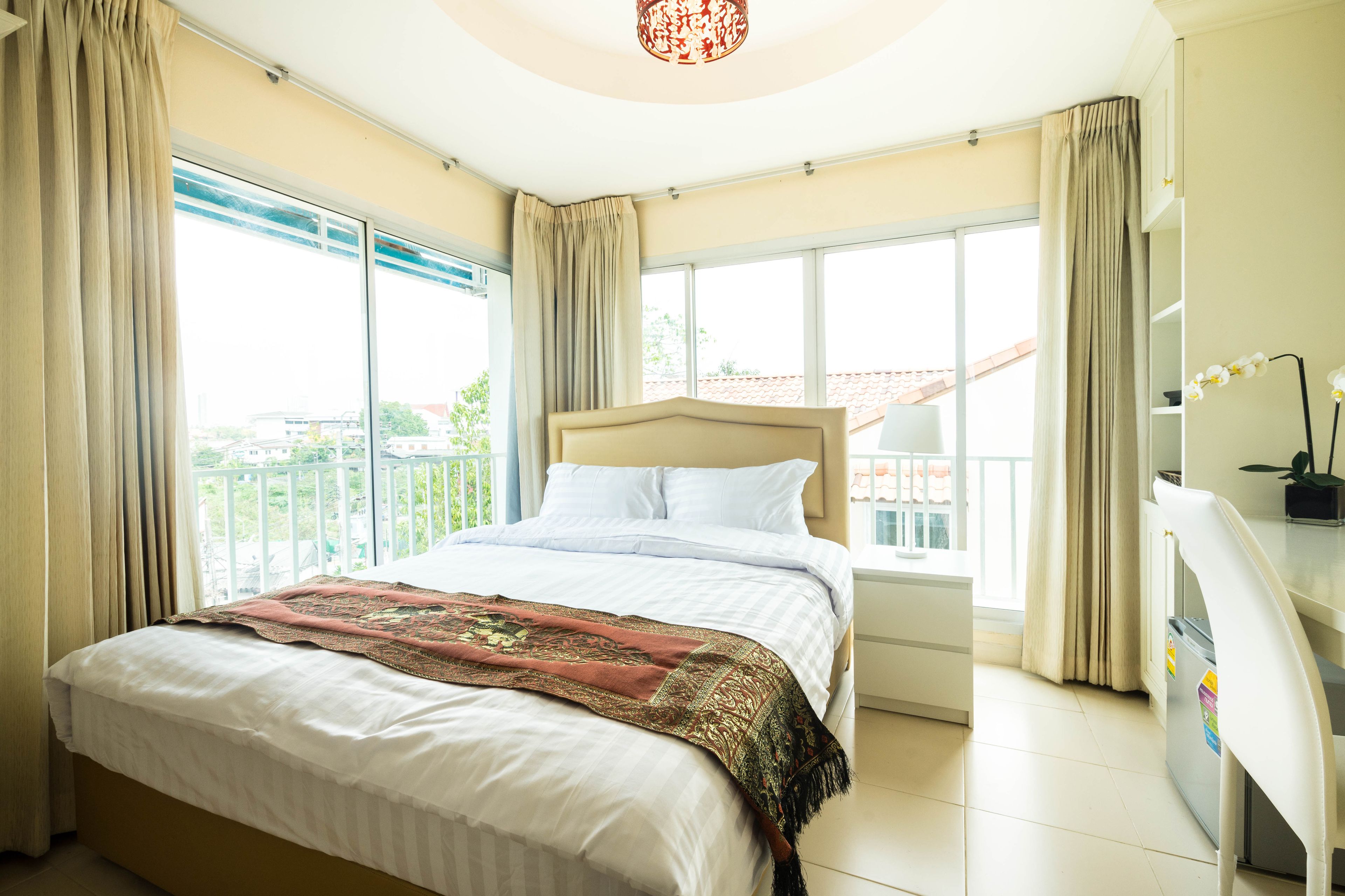 Quarto de hotel com uma cama grande, uma escrivaninha e vista para o exterior.