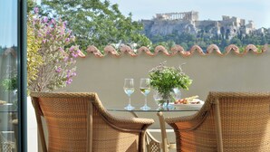Uma mesa com duas taças de vinho e um vaso de flores, com vista para ruínas antigas.