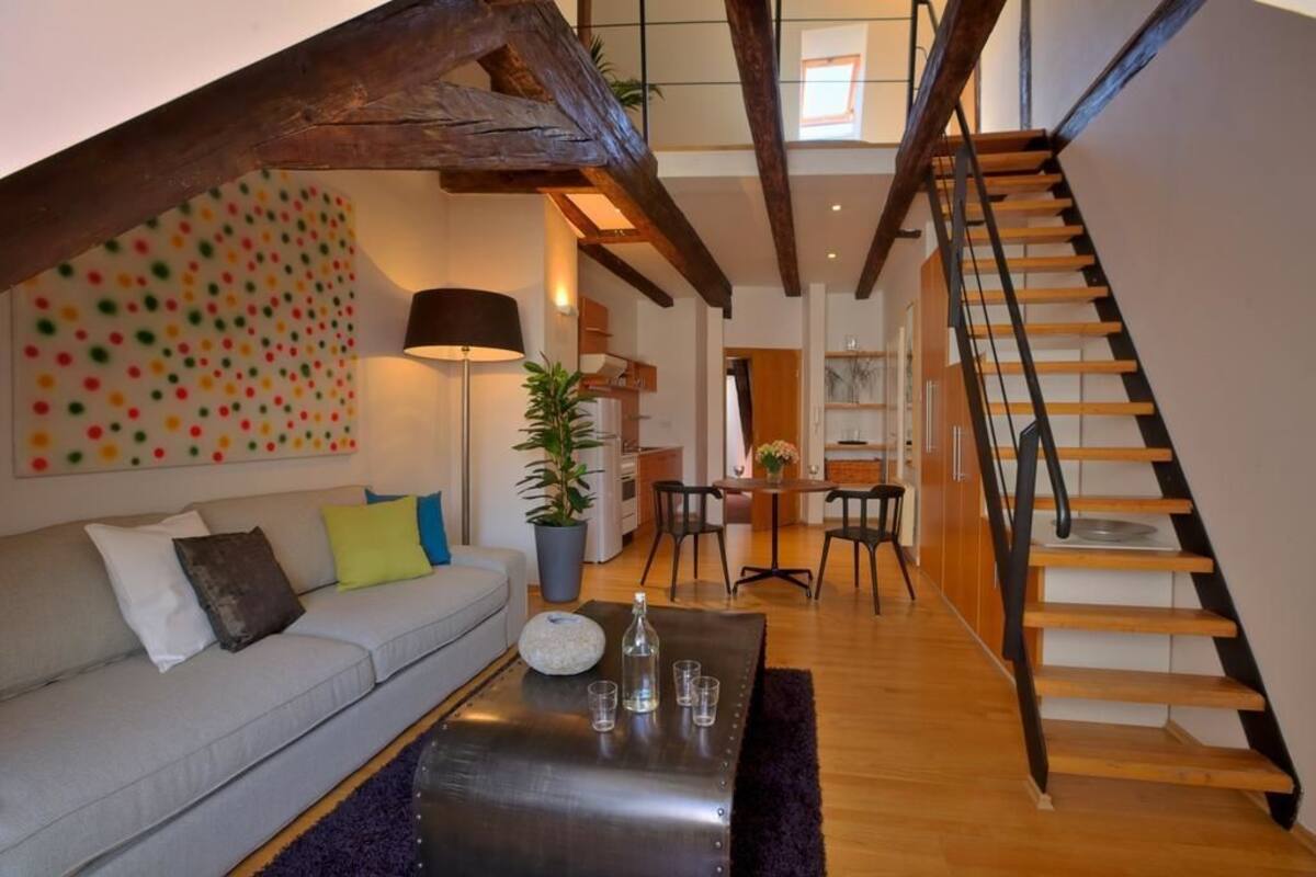 Uma sala de estar moderna com um sofá, mesa de centro e escada.