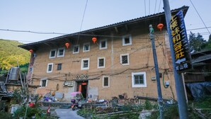 Um edifício tradicional com várias janelas e uma placa.