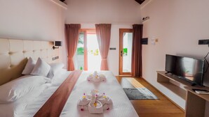 Quarto de hotel com uma cama, televisão e vista para o exterior.