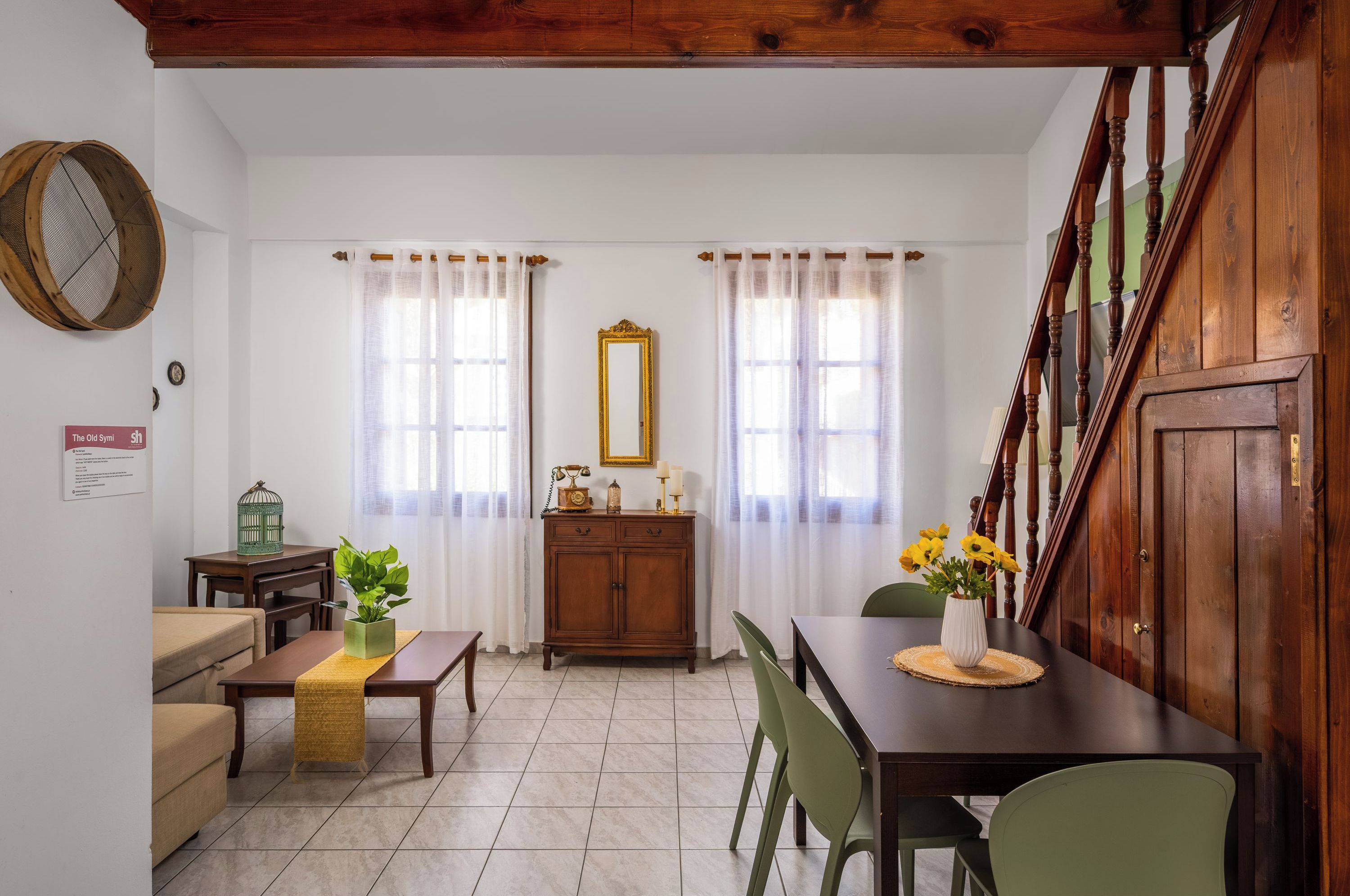 Uma área de refeições com uma mesa de madeira, cadeiras, um armário e um espelho.