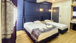 Quarto com uma cama grande, duas mesas de cabeceira, um guarda-roupa e uma pequena escrivaninha com espelho.