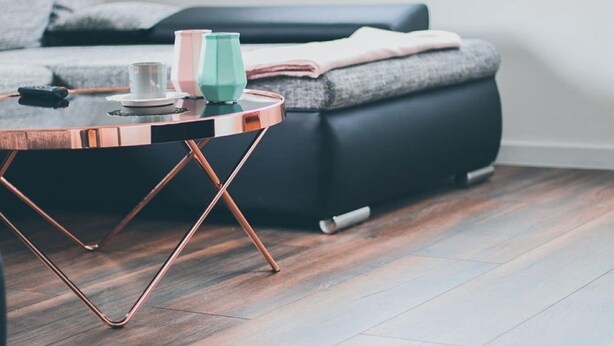 Uma sala de estar moderna com uma mesa de centro redonda, um sofá e um tapete.