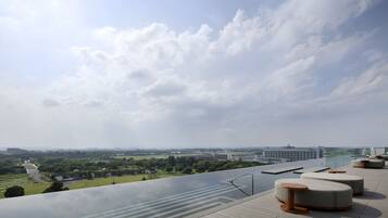 Terraço no telhado com área de estar ao ar livre e vista para a paisagem urbana.