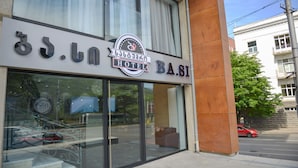 Placa de hotel com o nome 'BASI HOTEL' e um logotipo.