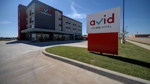 Um hotel Avid com um edifício moderno, céu claro e gramado bem cuidado.