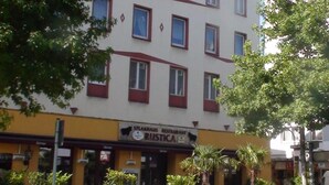 Um edifício de vários andares com um restaurante no andar térreo chamado "Rustica".