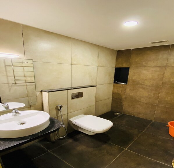 Uma casa de banho moderna com lavatório, sanita e chuveiro.
