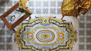 Piso de azulejos com um desenho central grande e ornamentado, rodeado por azulejos menores com padrões.