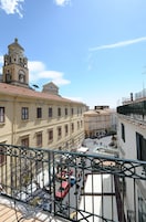 Um edifício histórico com uma torre de sino e um pátio.
