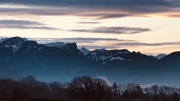 Paisagem montanhosa com picos cobertos de neve e céu claro.