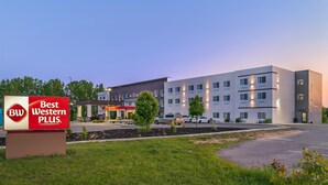 Um hotel Best Western Plus com design moderno, vários andares e uma área de estacionamento em frente.