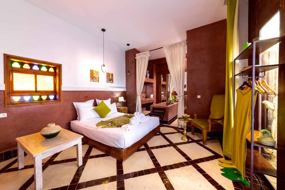 Quarto de hotel com cama, mesa de cabeceira e guarda-roupa.