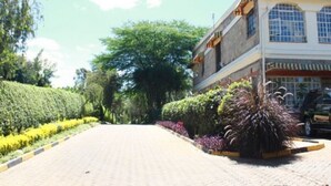 Uma entrada pavimentada que leva a um edifício, com um carro estacionado na frente.