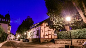 Um edifício tradicional em enxaimel com uma placa que indica ser um hotel.