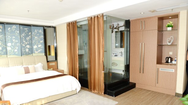 Quarto moderno com cama grande, chuveiro em gabinete de vidro e guarda-roupa de madeira.