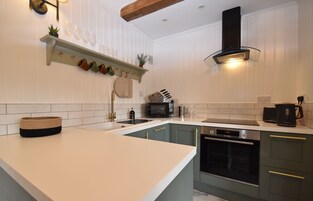 Uma cozinha moderna com uma ilha grande, eletrodomésticos embutidos e um suporte de vinhos diferenciado.